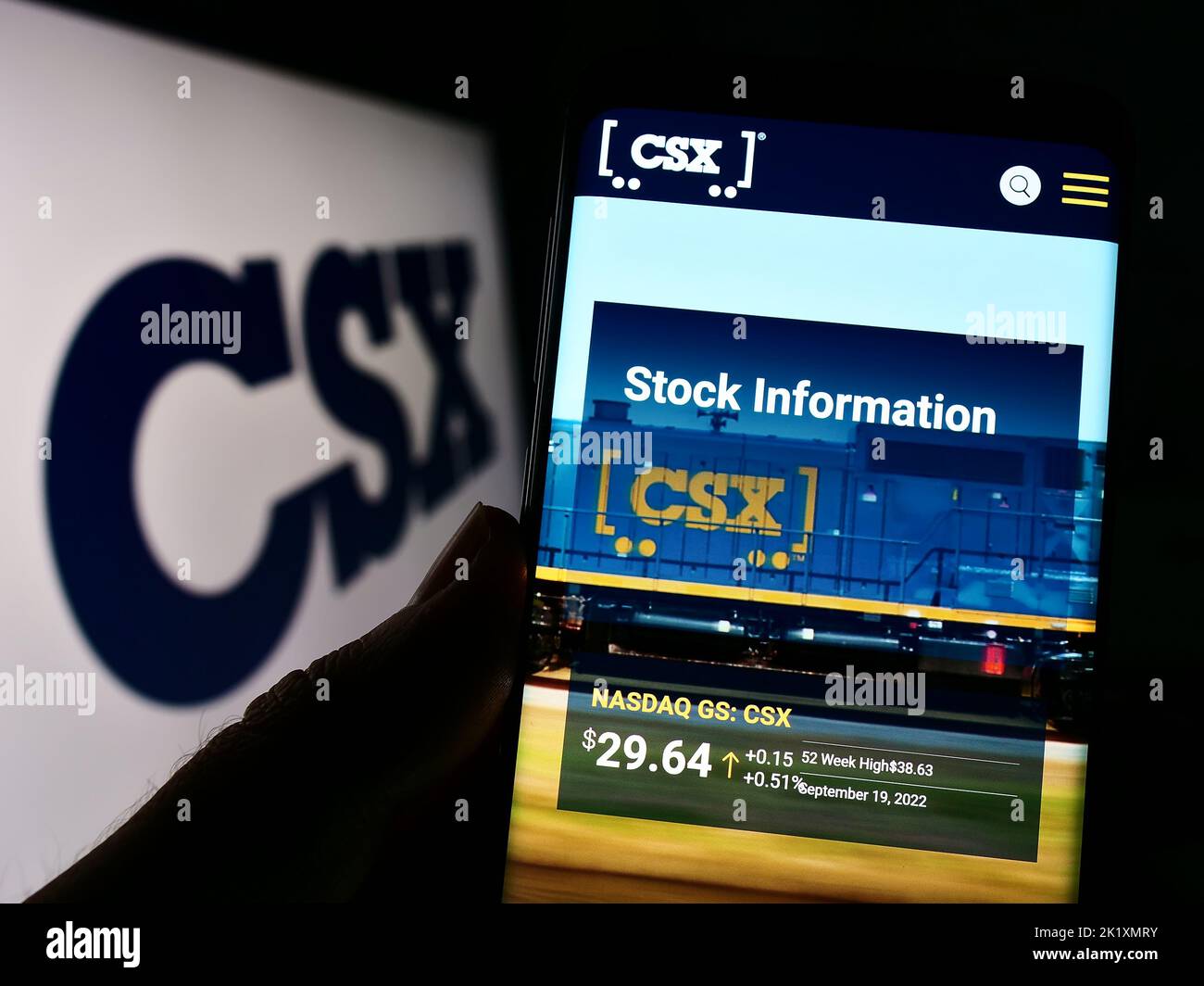 Person holding smartphone with webpage of US transportation company CSX ...