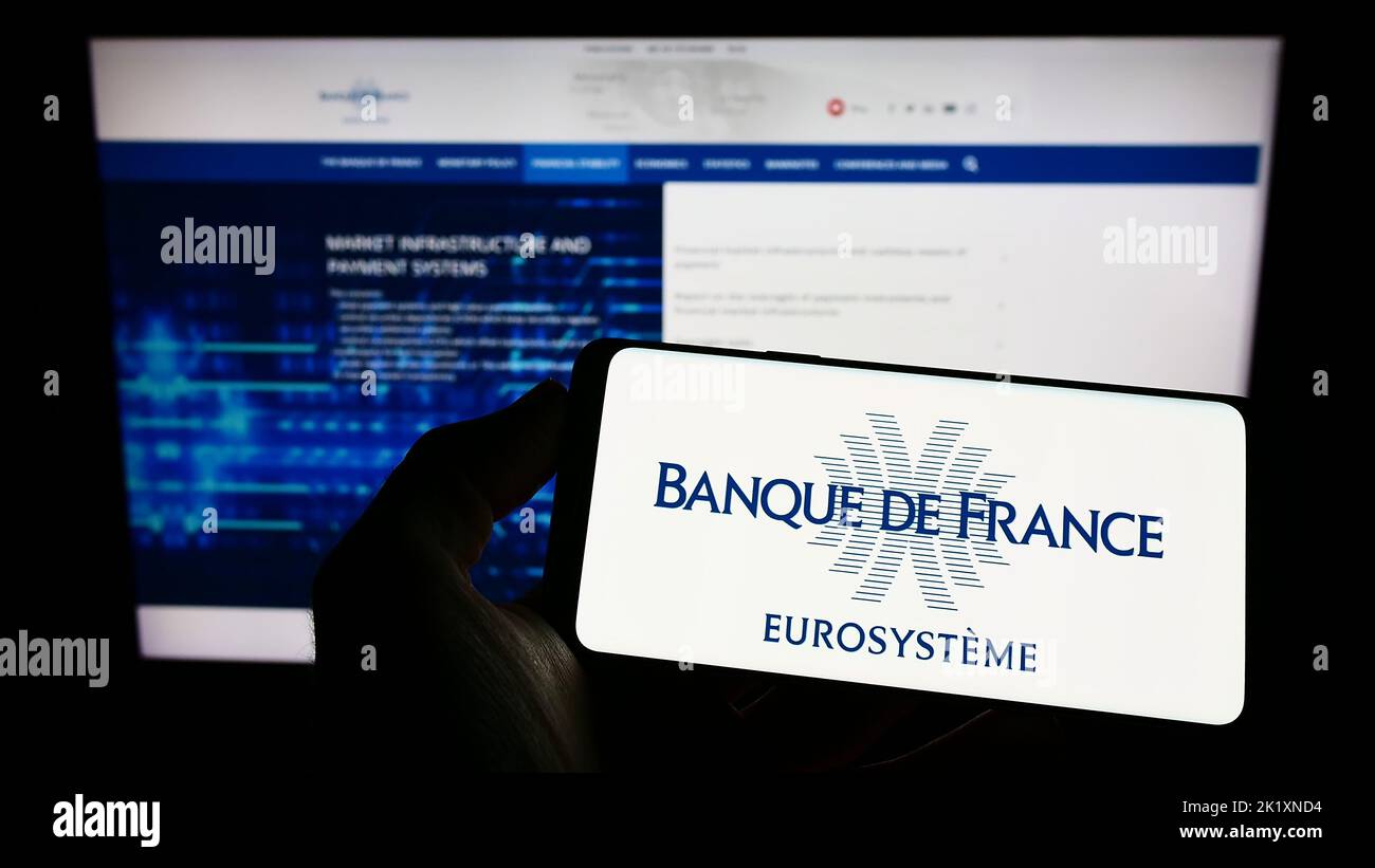 Person holding mobile phone with logo of French central bank Banque de ...