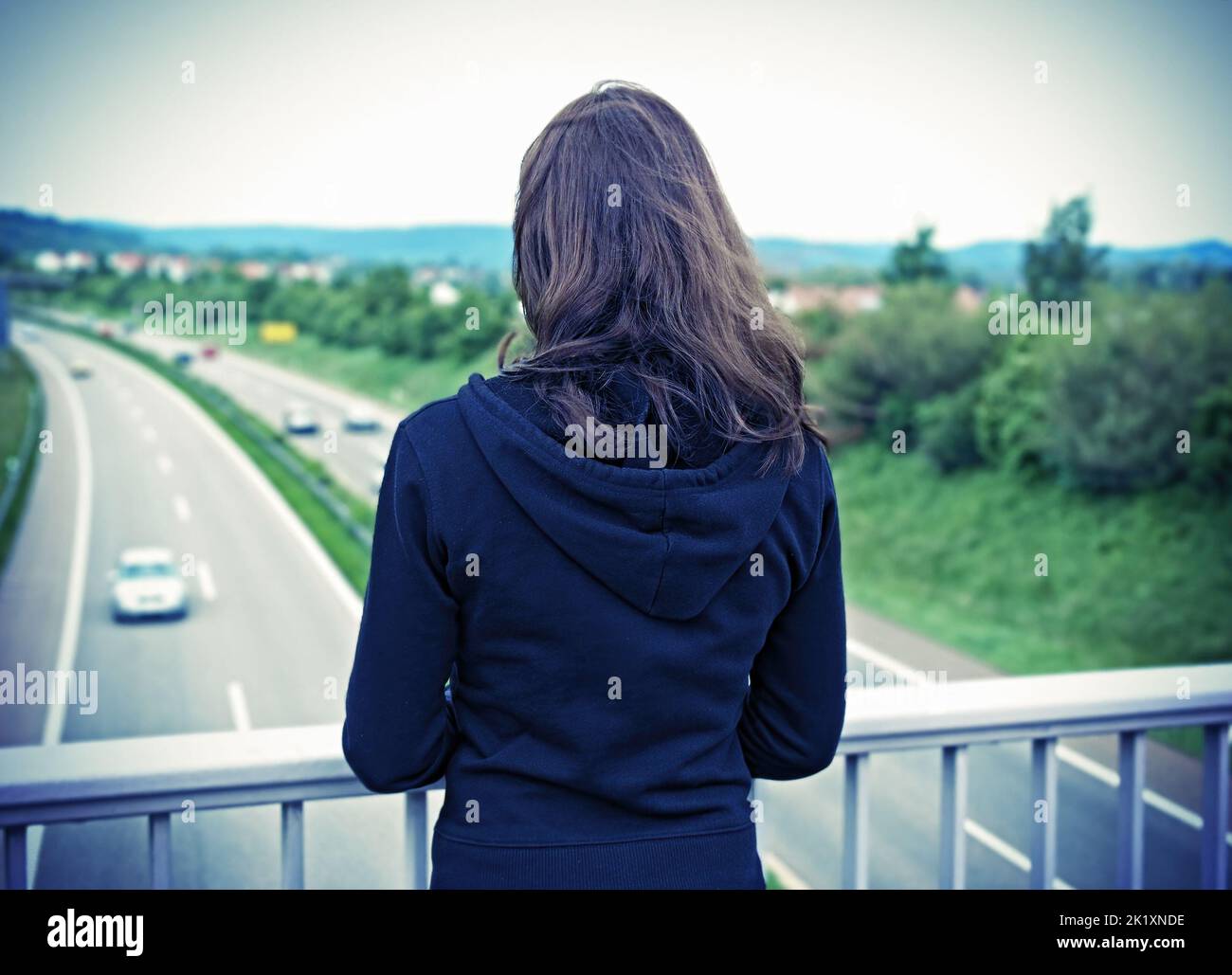 Young, sad woman on a bridge Stock Photo - Alamy