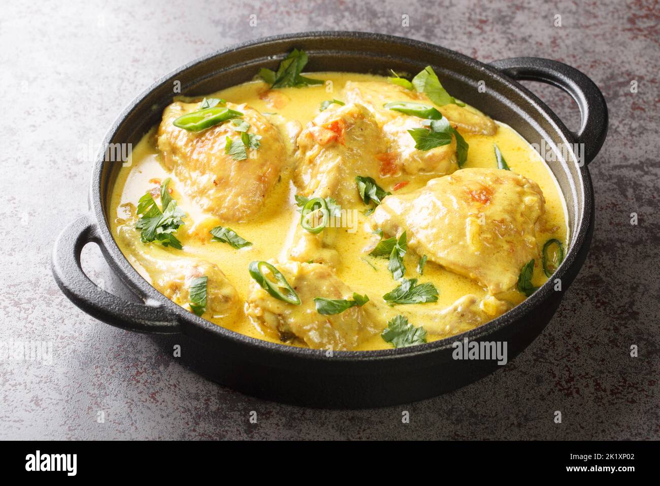 Kuku paka Kenyan chicken in coconut curry sauce closeup in the pan on ...