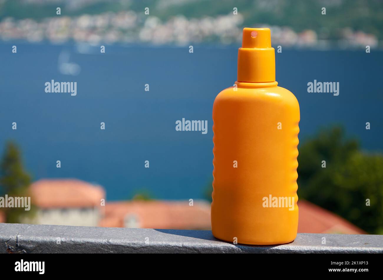 Orange bottle of a sun lotion spray with a sea in a background Stock ...