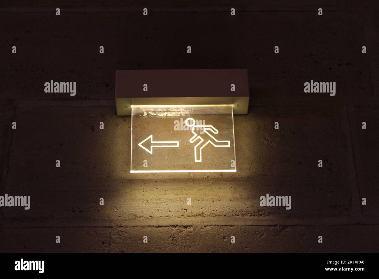 Illuminated white glass exit sign on the wall at night Stock Photo - Alamy