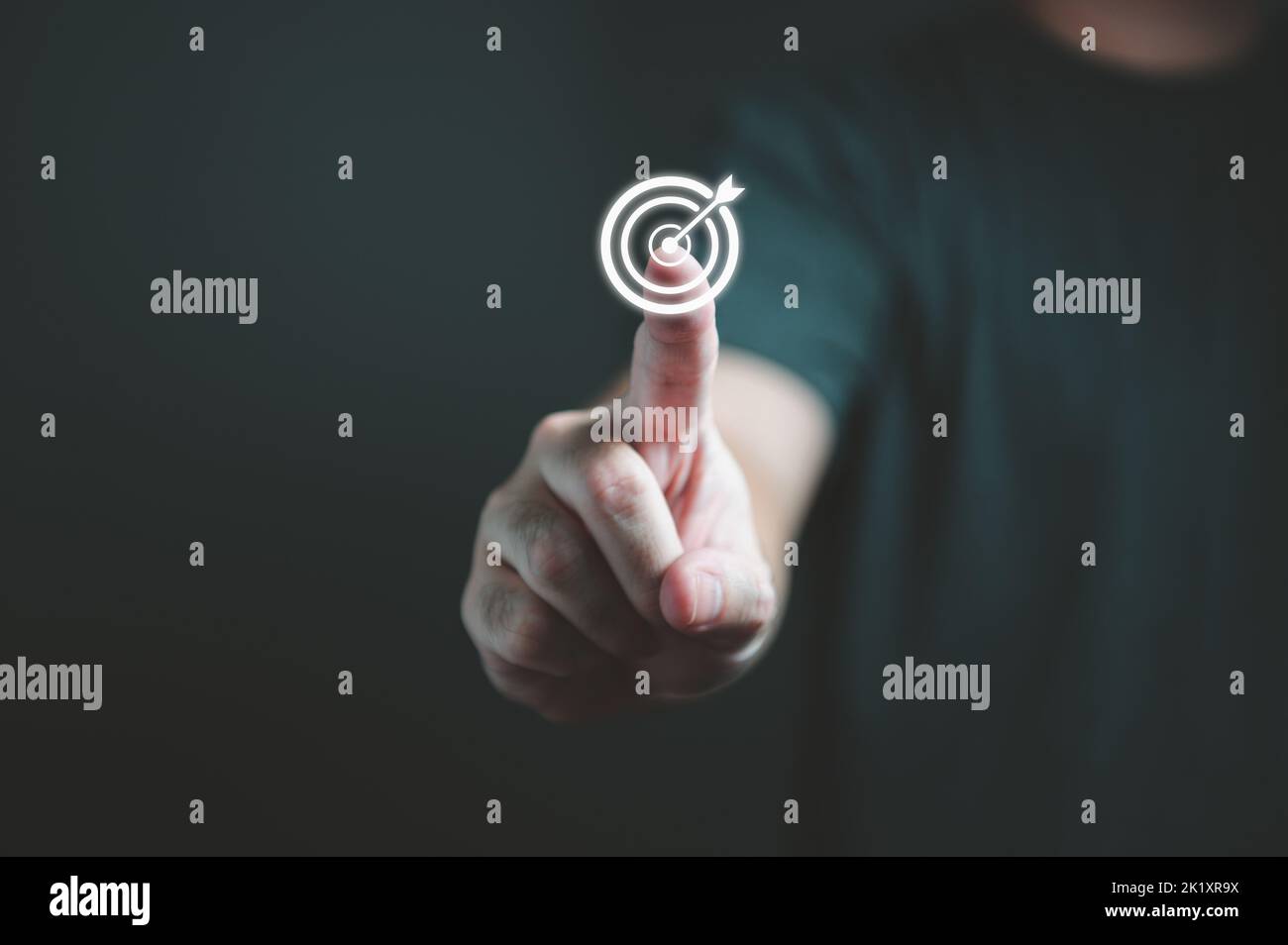 Businessman hand touching target dartboard to setup goal and ...