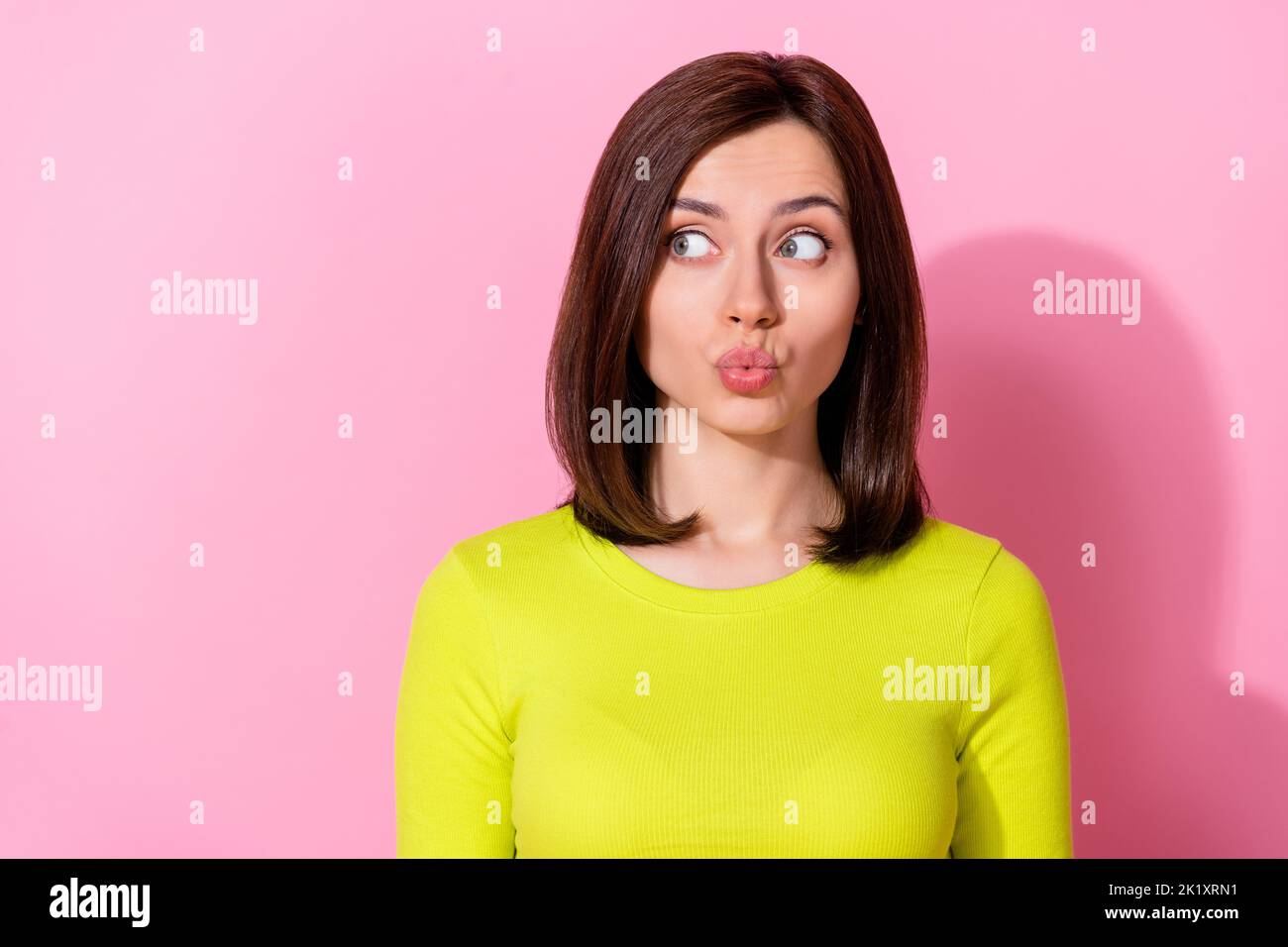 Photo of charming cute lady kiss lips look interested empty space ...
