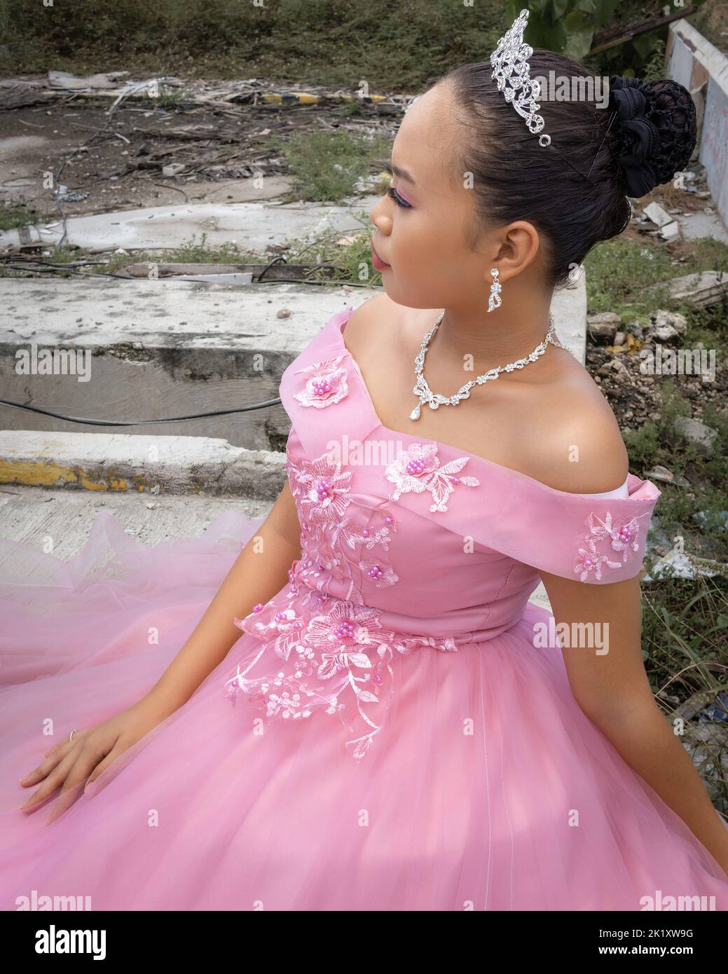 A philippine princess wearing a pink dress and a crown and sitting ...