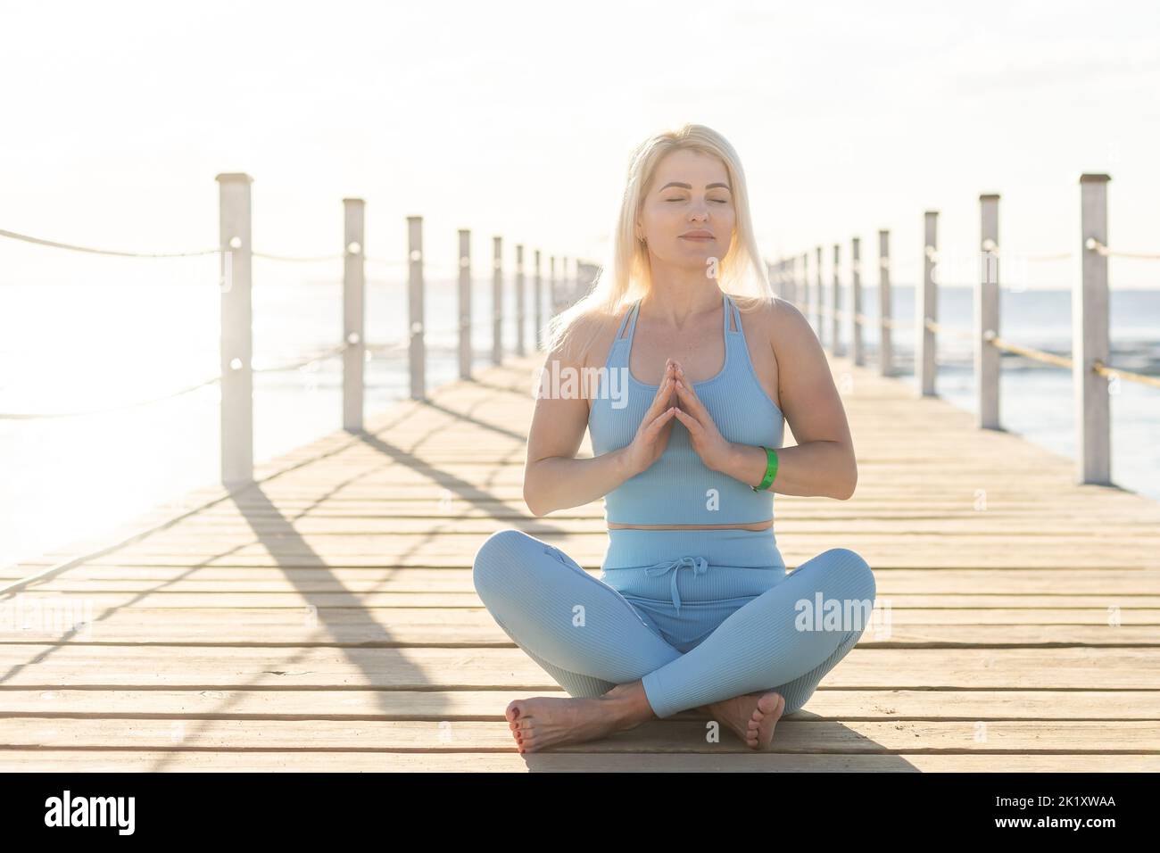 Woman doing yoga exercises by the sea Stock Photo - Alamy