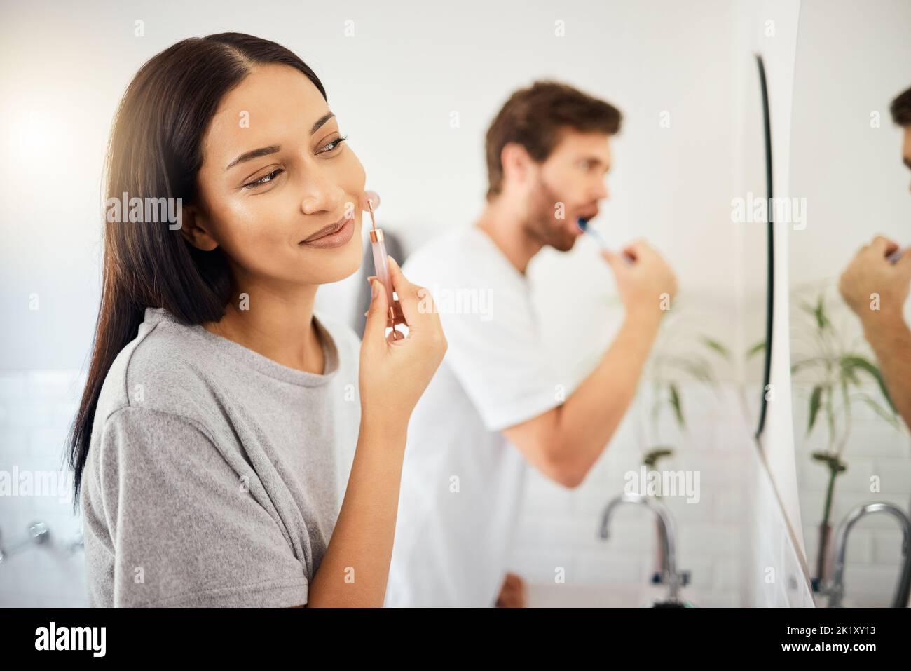 Makeup, face and beauty with a woman using cosmetics in the bathroom at ...