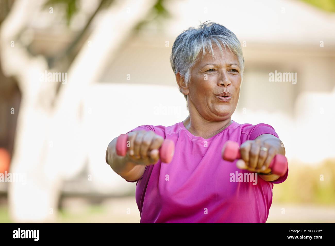 Staying Strong In Her Senior Years A Mature Woman Lifting Dumbbells