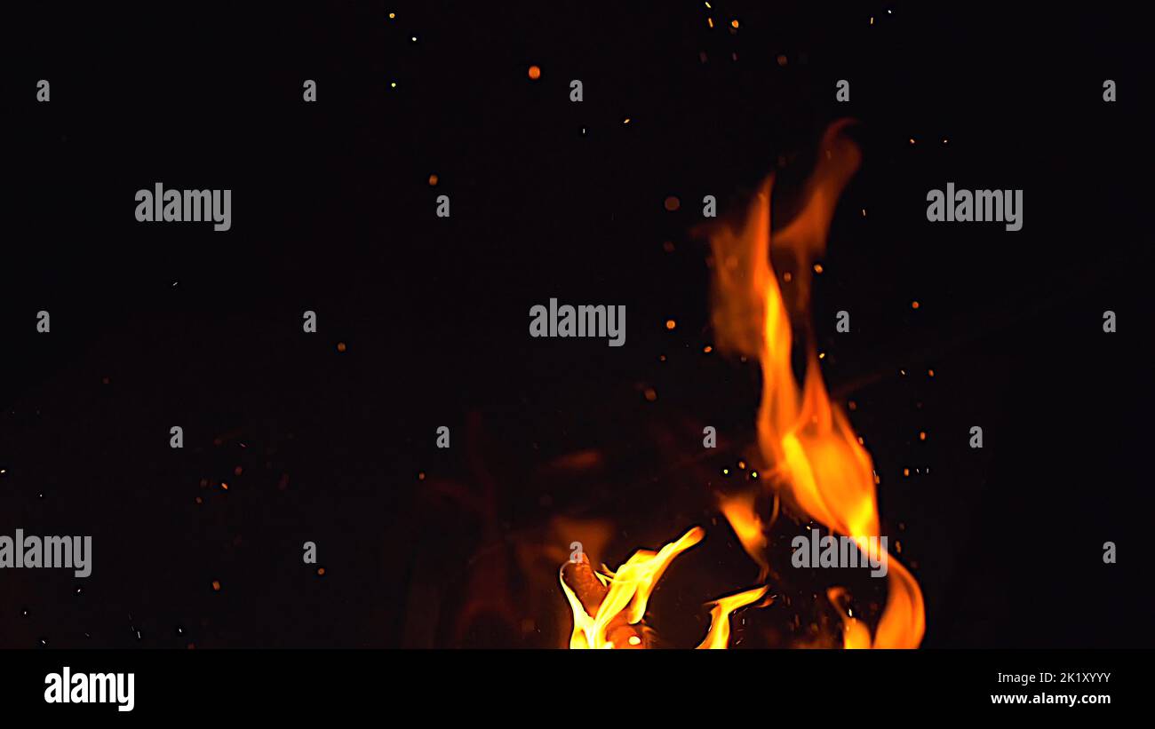 Fire flames and a lot of bright sparks are flying from the fire at ...