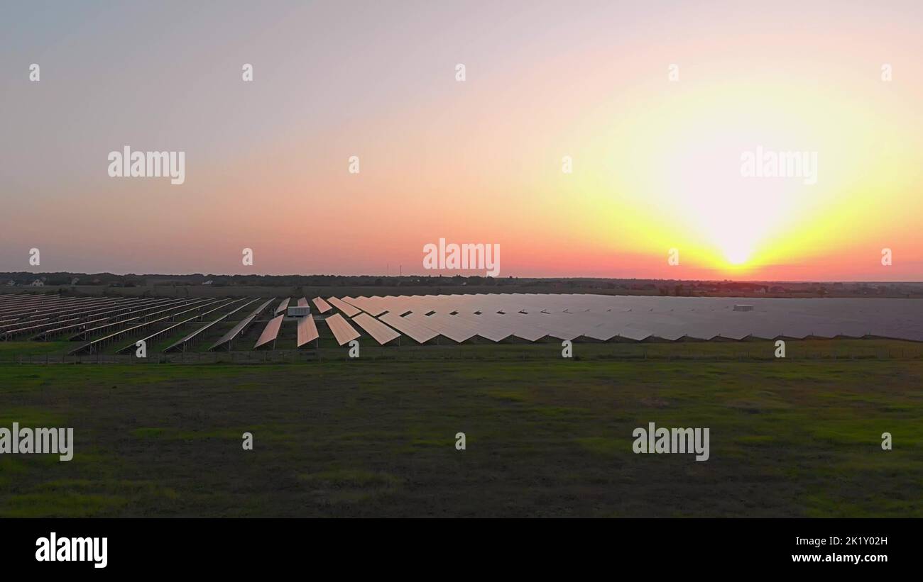 Large solar panels at a solar farm at summer sunset. Solar cell power ...