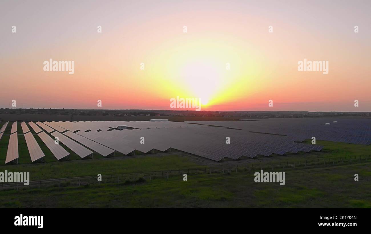 Large solar panels at a solar farm at summer sunset. Solar cell power ...