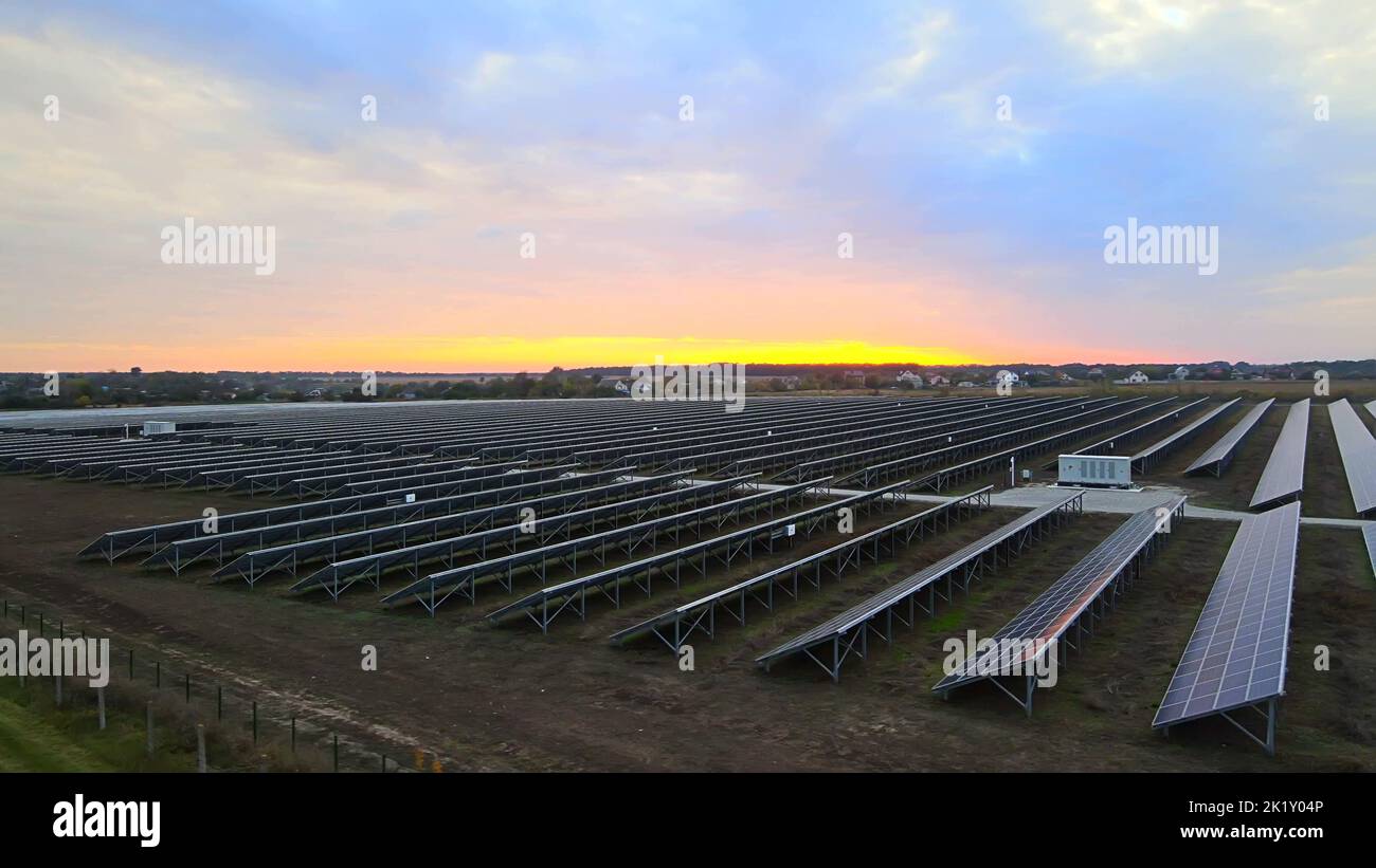 Large solar panels at a solar farm at summer sunset. Solar cell power ...