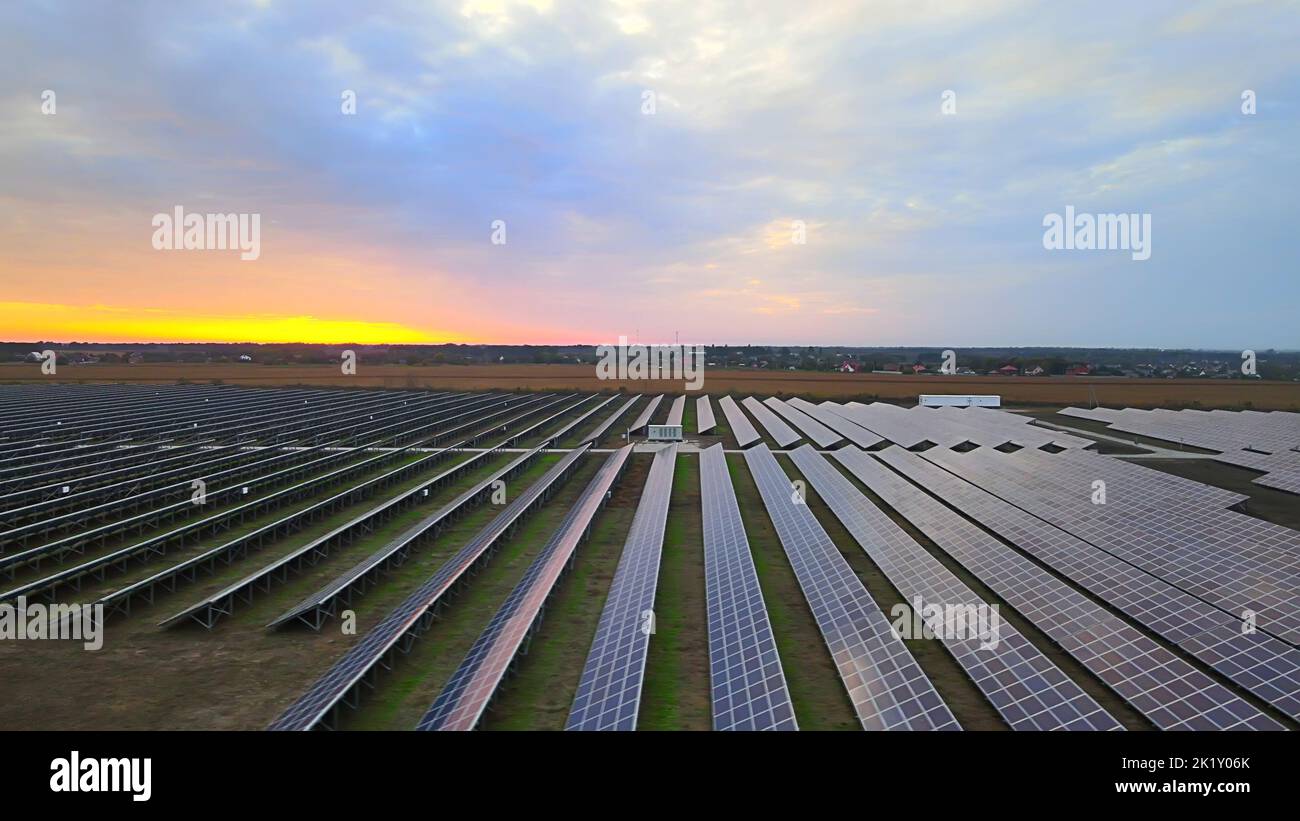 Large solar panels at a solar farm at summer sunset. Solar cell power ...