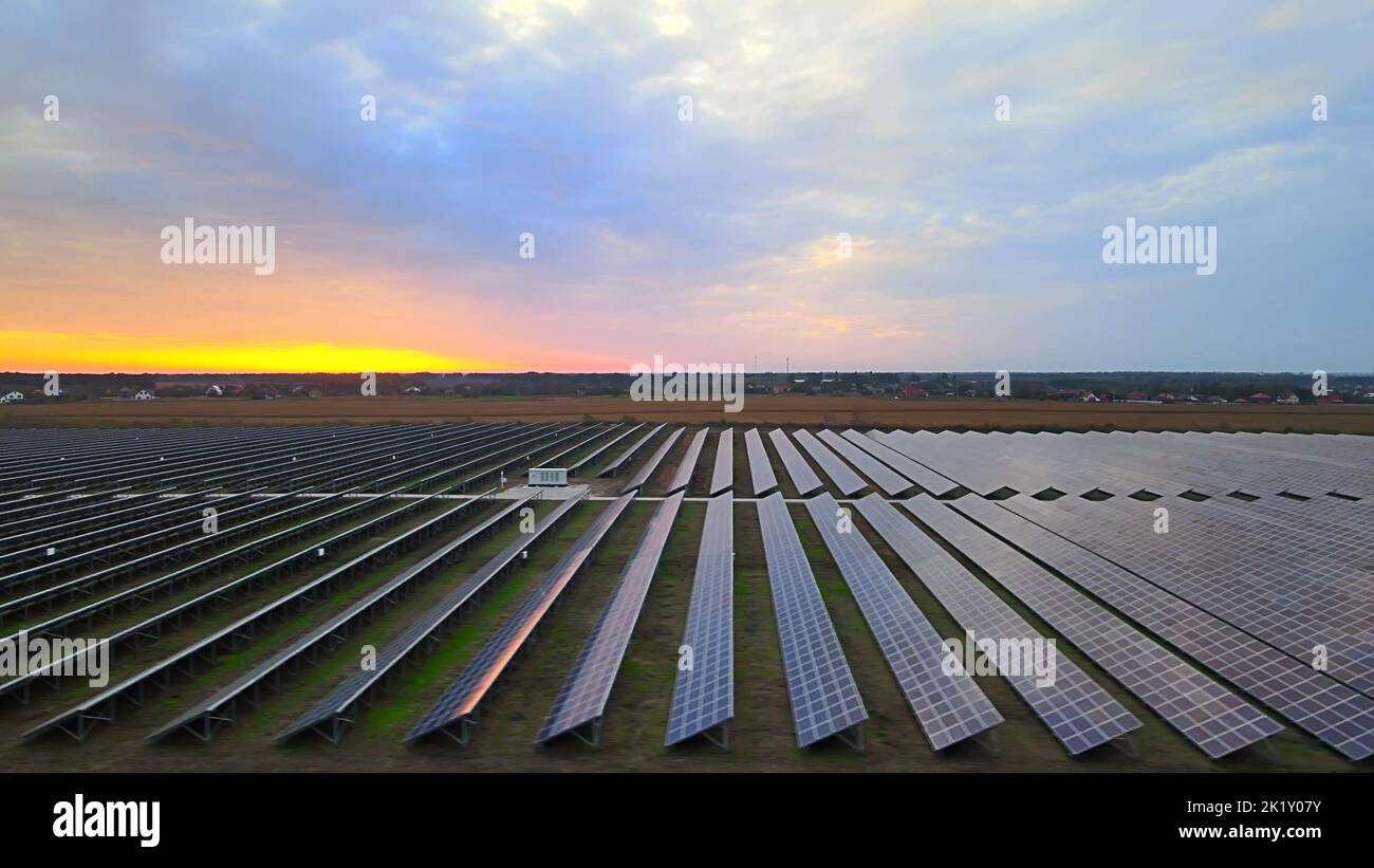 Large solar panels at a solar farm at summer sunset. Solar cell power ...