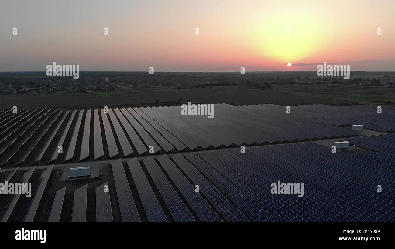 Large solar panels at a solar farm at summer sunset. Solar cell power ...