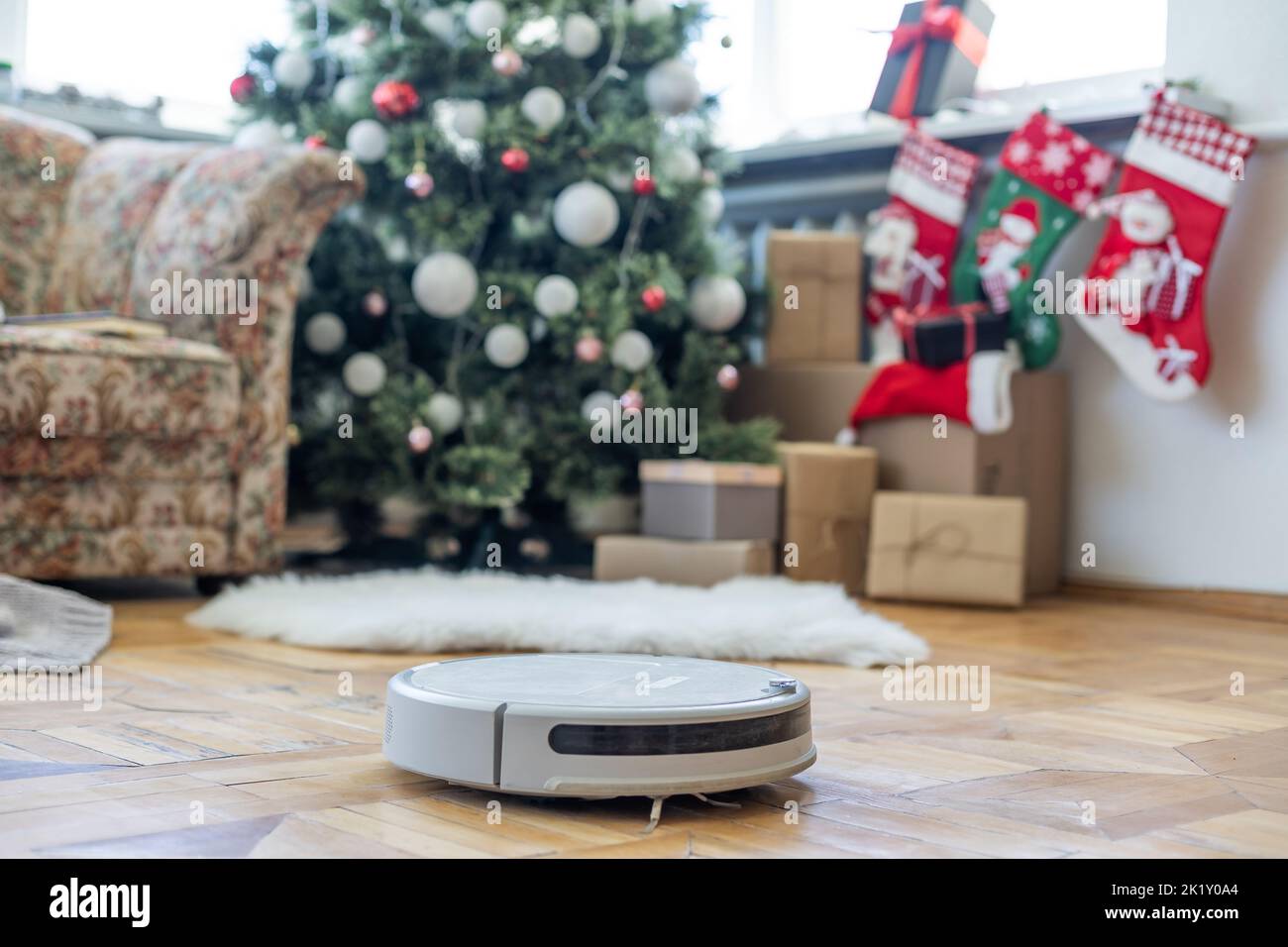 Robotic vacuum cleaner hoovering the floor at christmas Stock Photo - Alamy