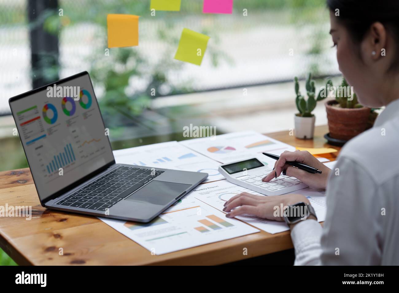 Asian Business Woman or Accountant do math and analyze with calculator ...