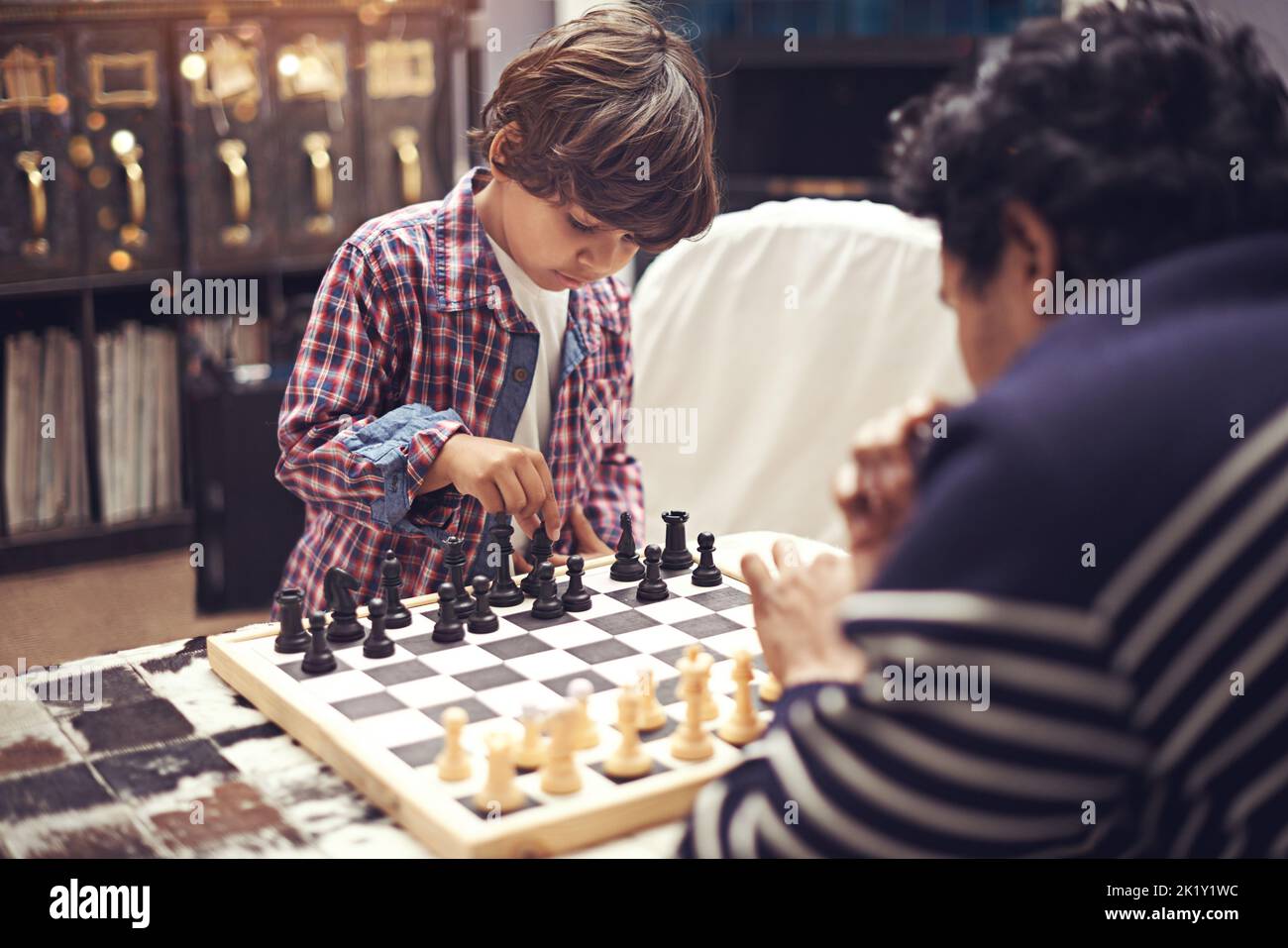 Making his move. a father and son playing a game of chess at home Stock ...