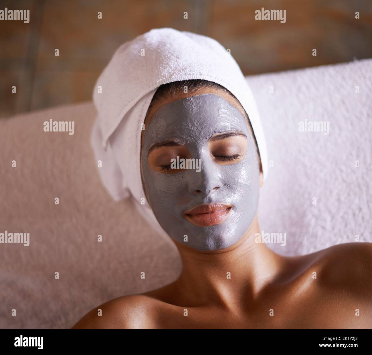 Serene skincare. A young woman relaxing during a facial treatment at a ...