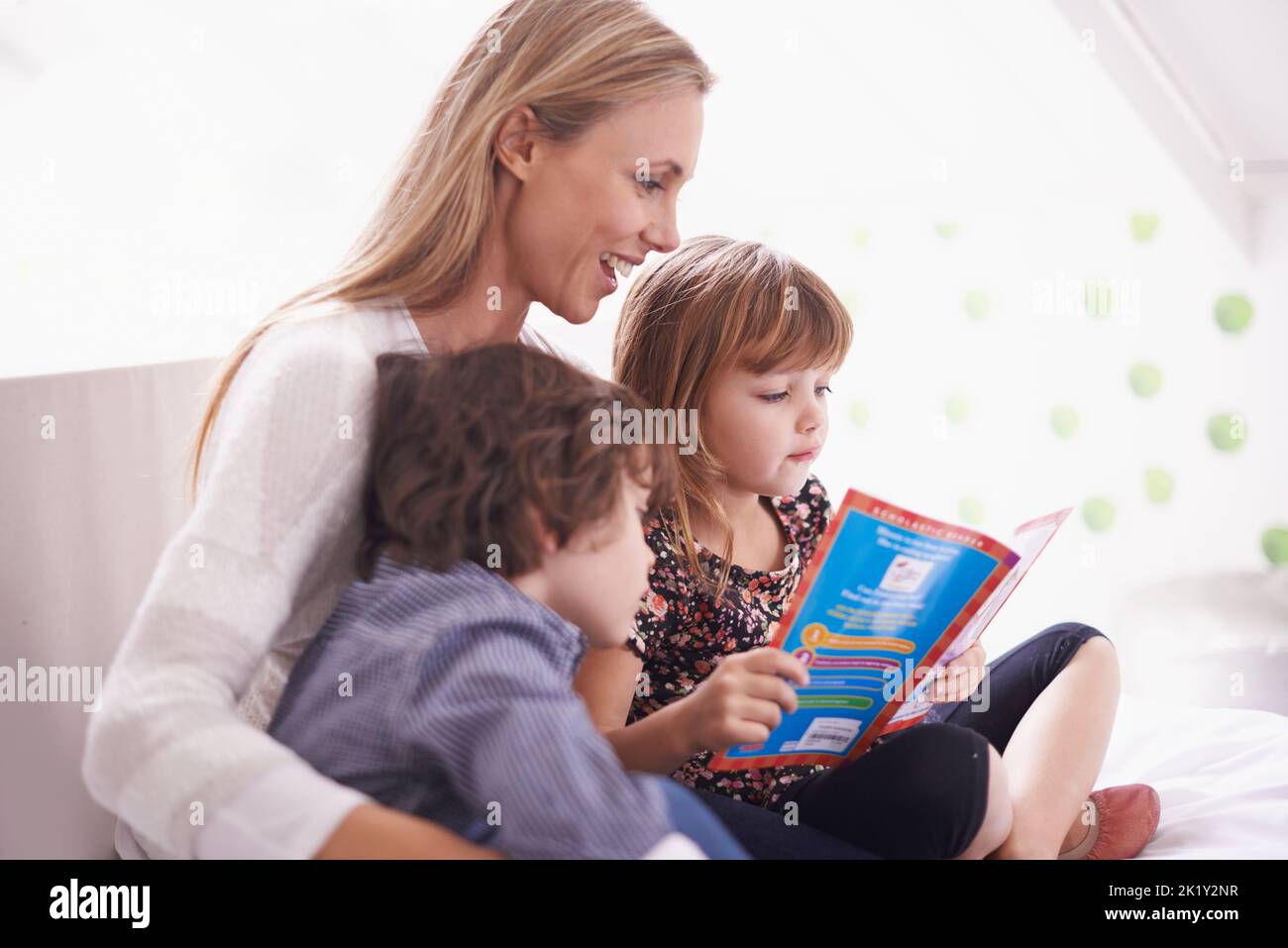 Bonding over a good storybook. a mother reading with her children at ...