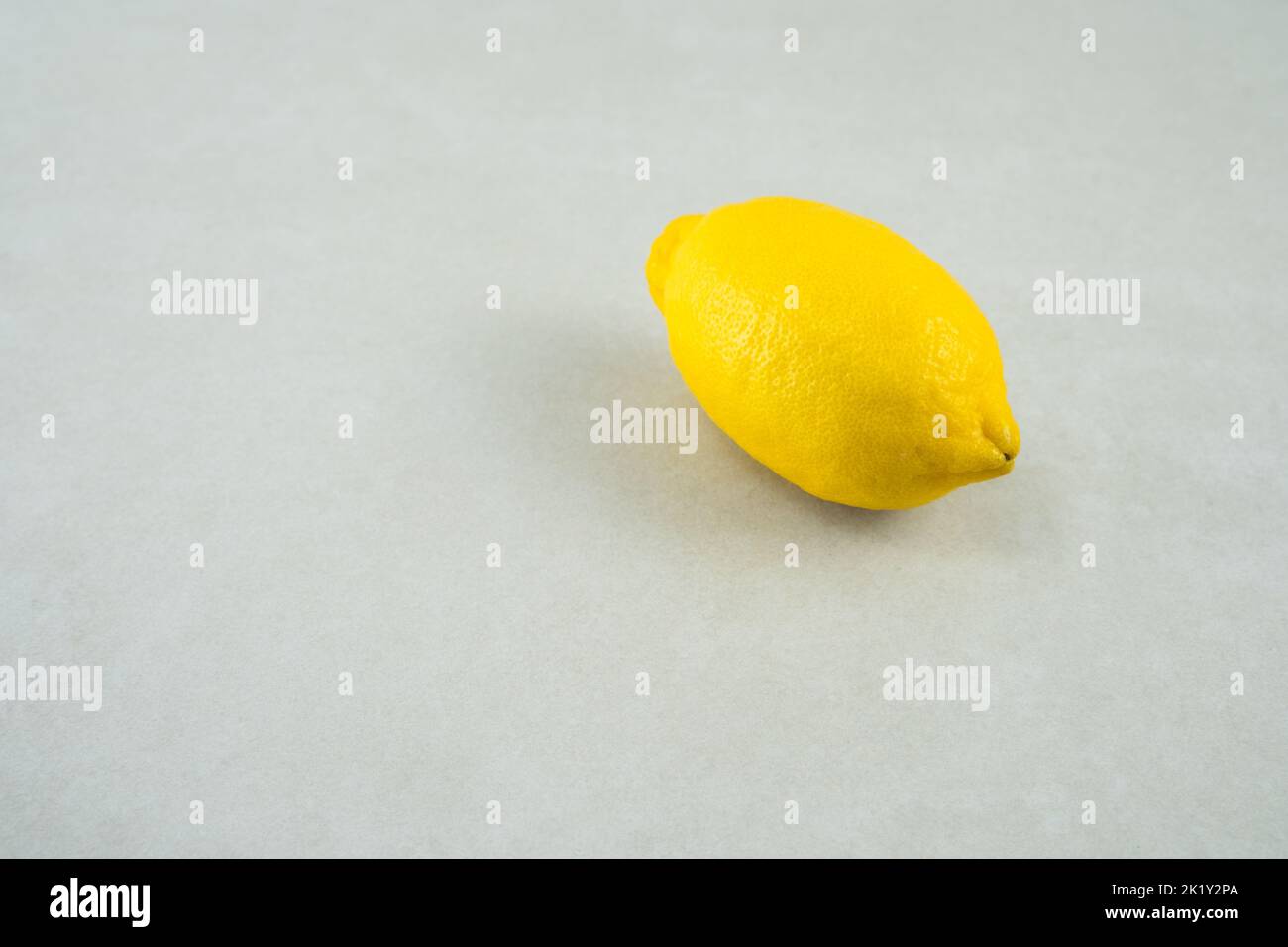 A top view of a yellow lemon placed on a grey background Stock Photo ...