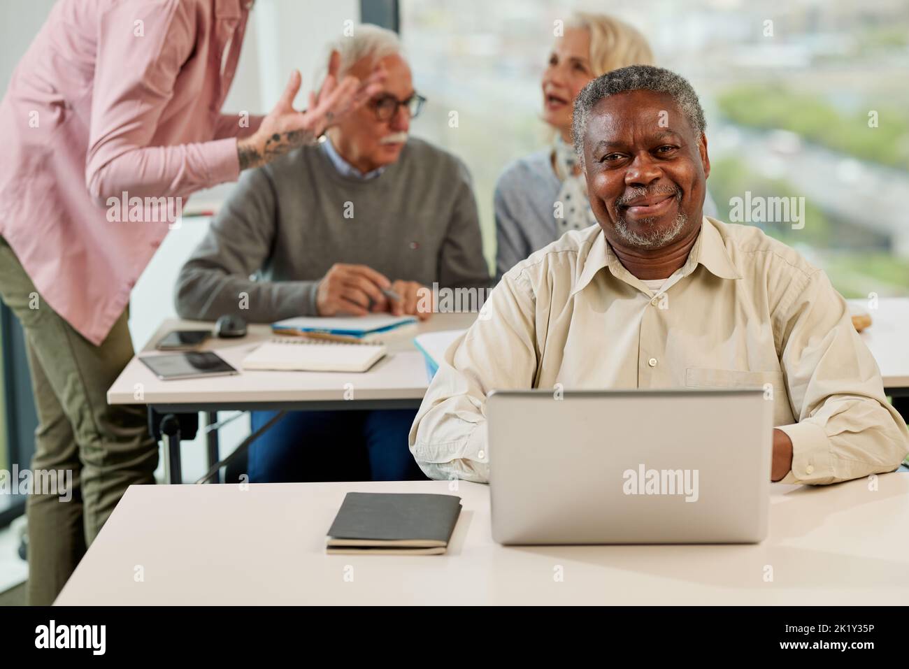 A senior african student smiling at the camera while group of ...