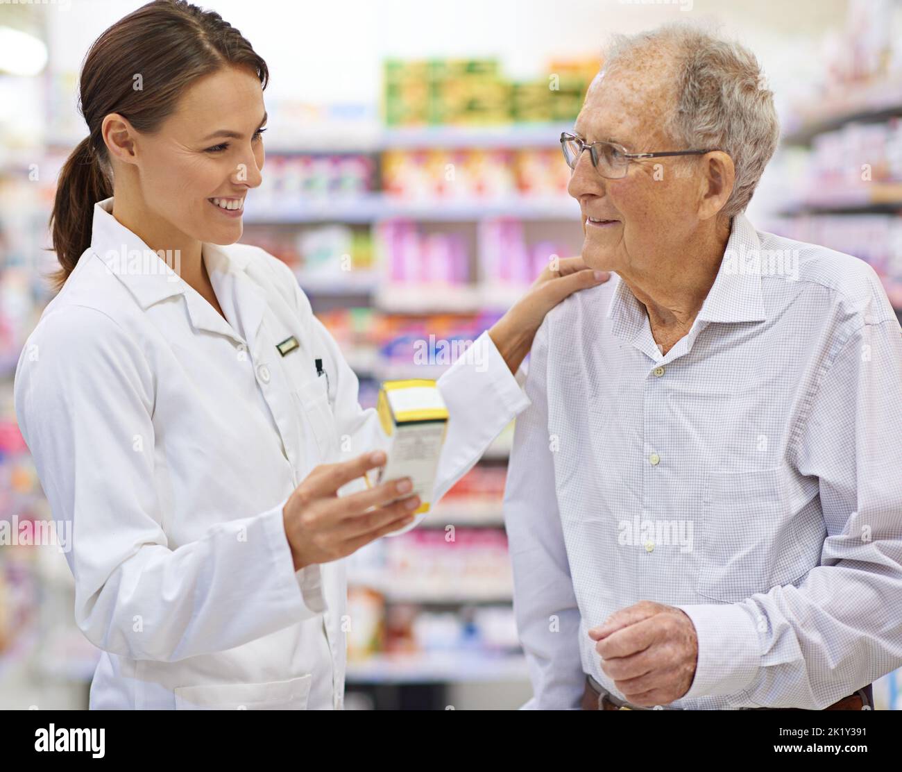 Finding the perfect remedy. a young pharmacist helping an elderly ...