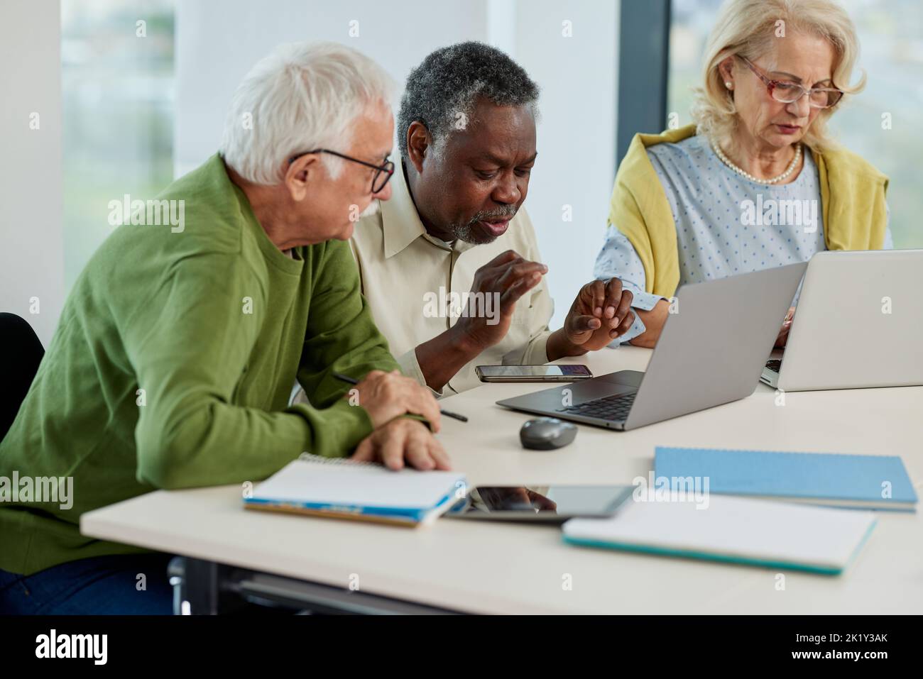 Senior students working on project on laptop in classroom Stock Photo ...