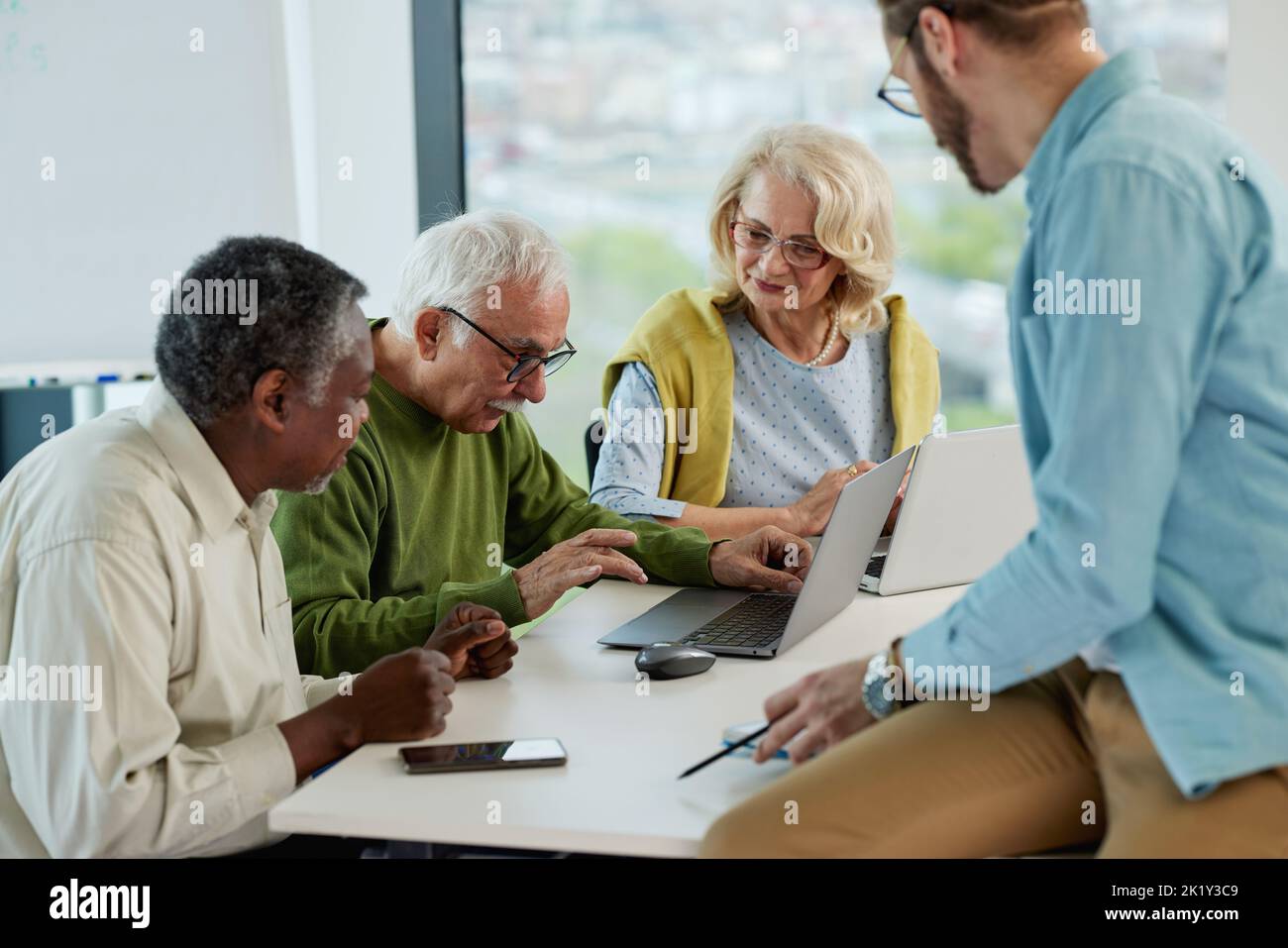 Multicultural group of senior students asking questions their tutor who ...