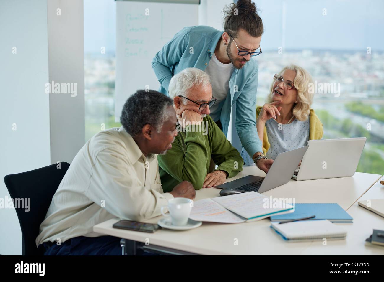 A small group of multicultural senior students is listening to the ...