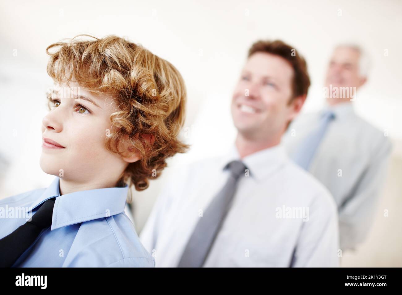 Going through the generations. a young boy standing with his father and ...
