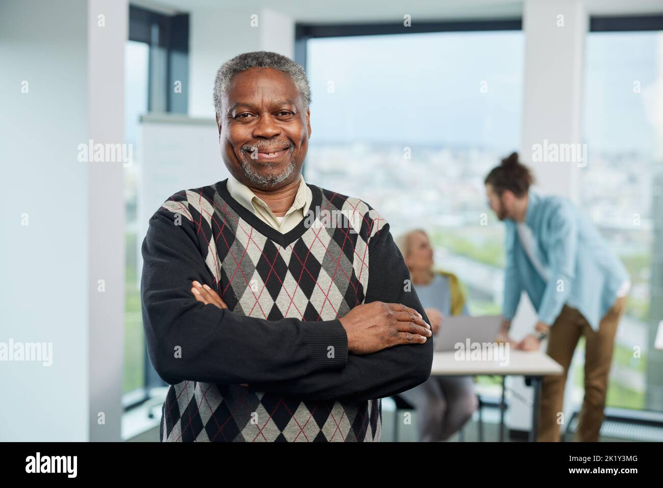 A smiling multicultural senior student is standing with arms crossed in ...
