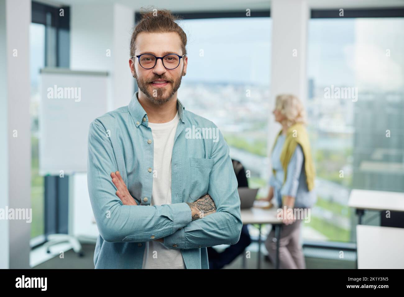 A successful, smart young professor is posing with arms crossed in ...