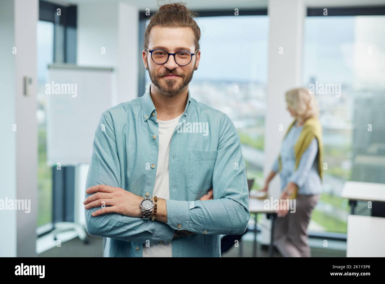 A happy, successful young professor is standing in a classroom and ...