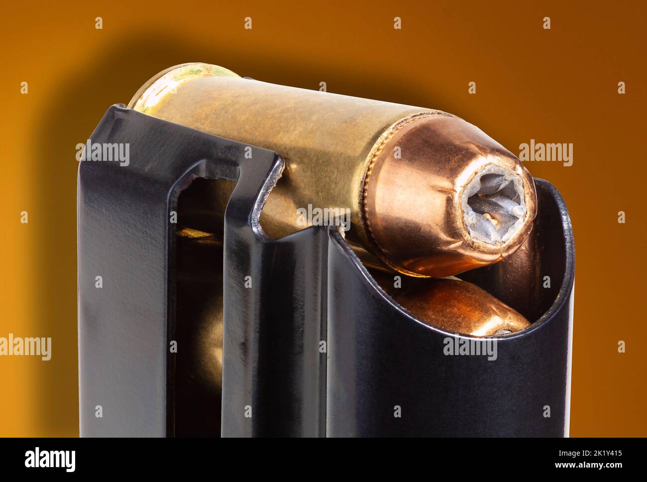 Hollow point bullet macro in a pistol magazine with orange background ...