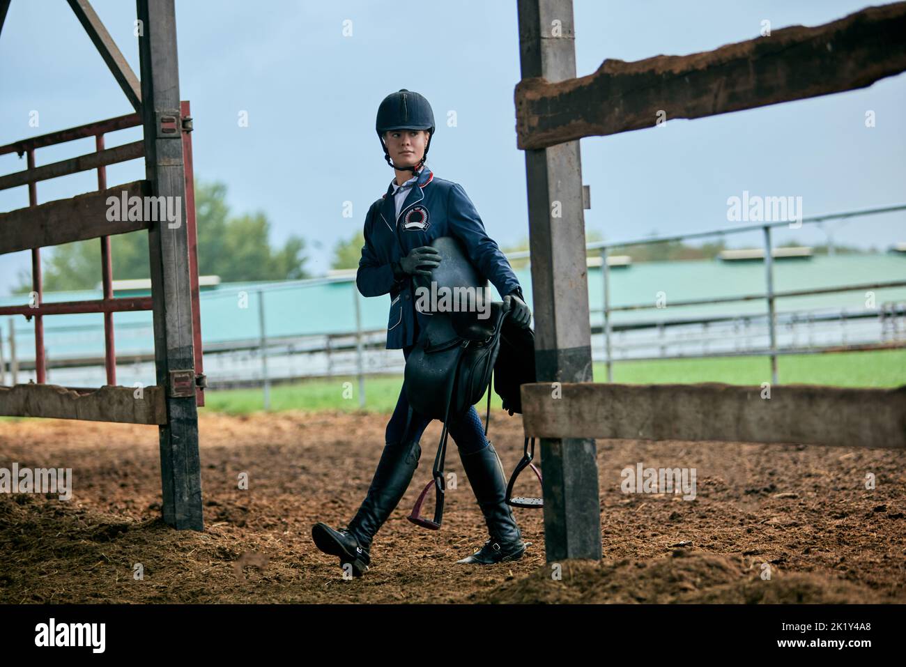 Portrait of young girl, jockey and horsewoman in competition uniform ...