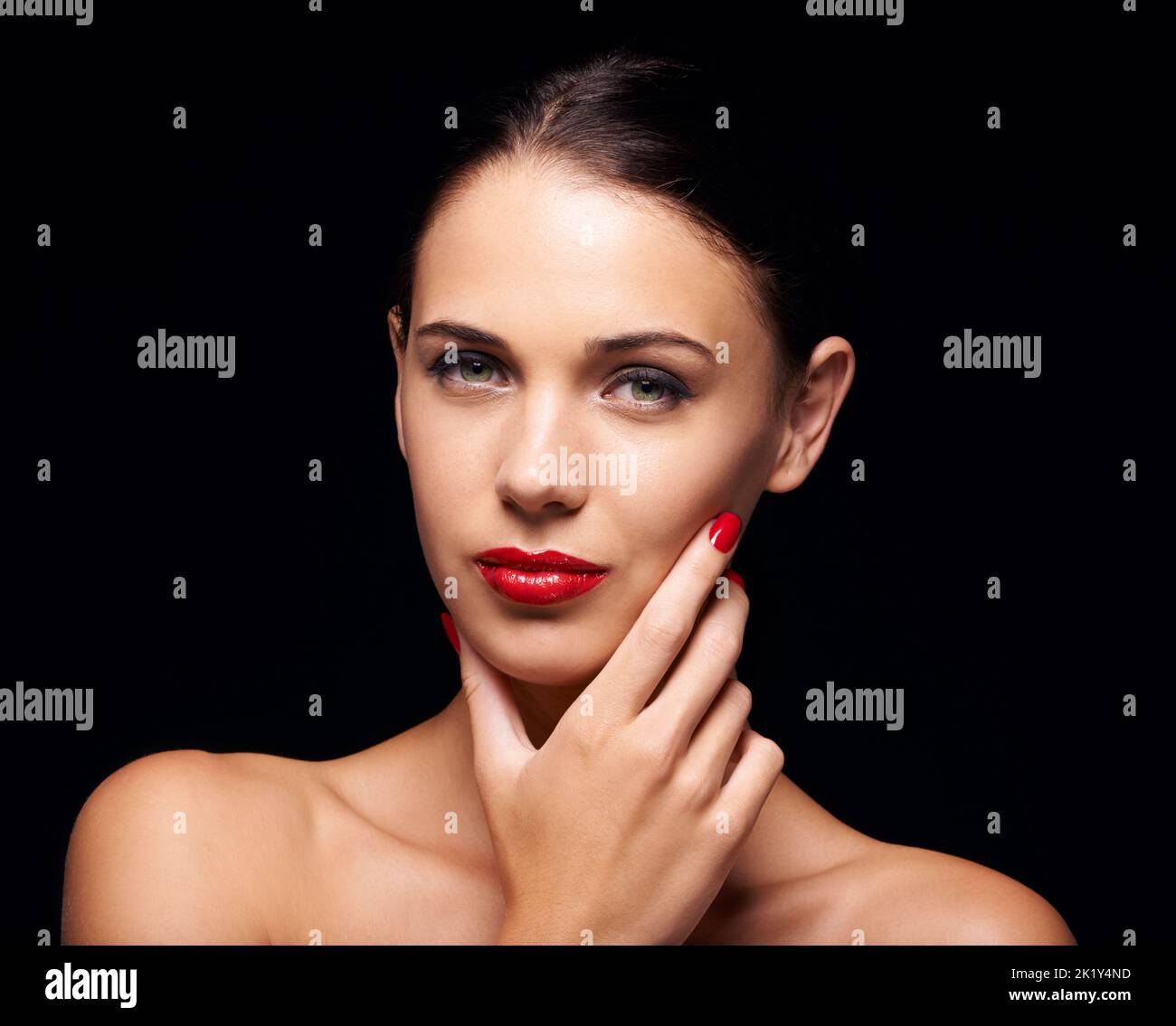 The lady in red. A stunning young woman isolated on a black background ...