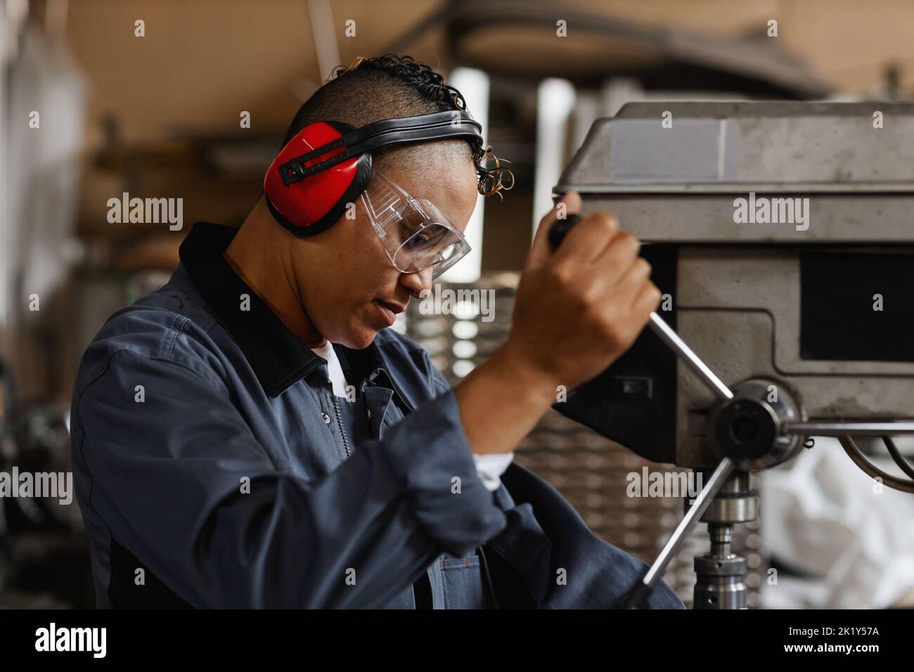 Side view portrait of female worker operating machine units in ...