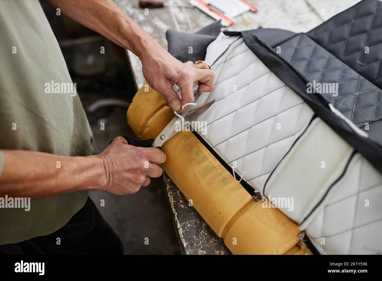 Close up of person fitting car upholstery and cutting extra threads ...