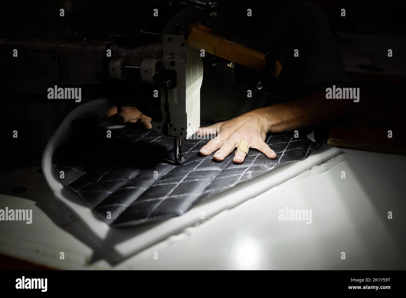 Close up of male worker sewing car upholstery detail with industrial ...