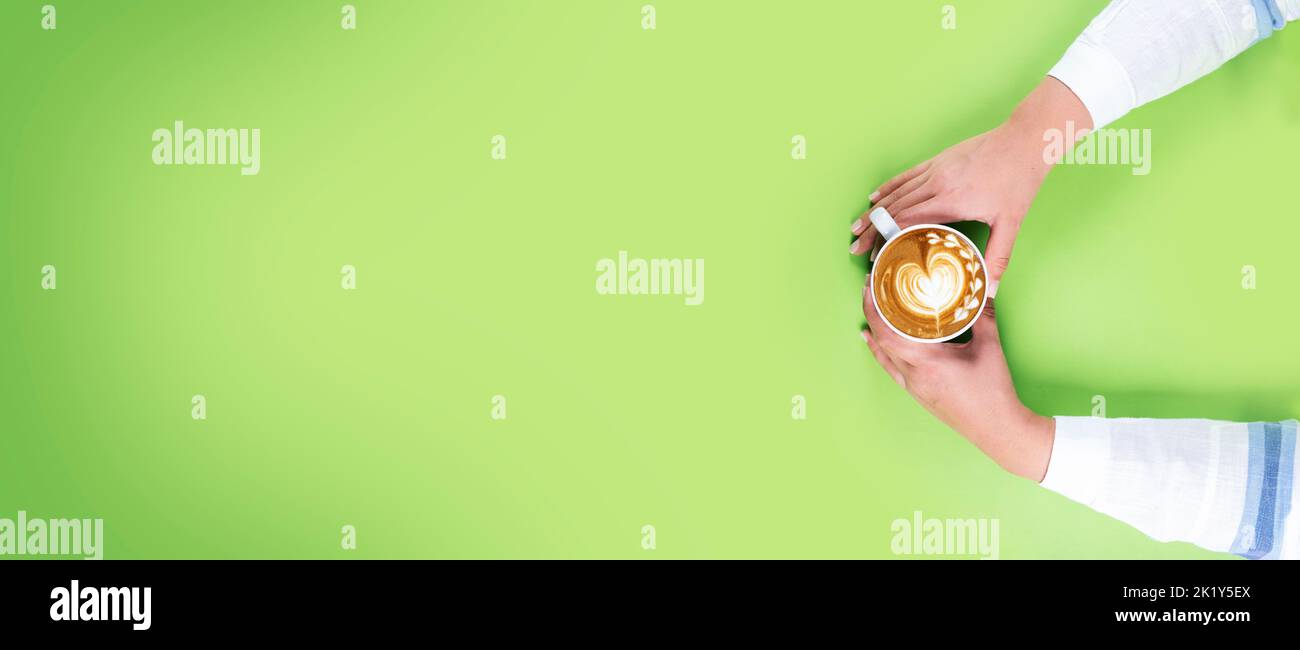 Hearth shape latte art, top view woman hand holding coffee mug with ...