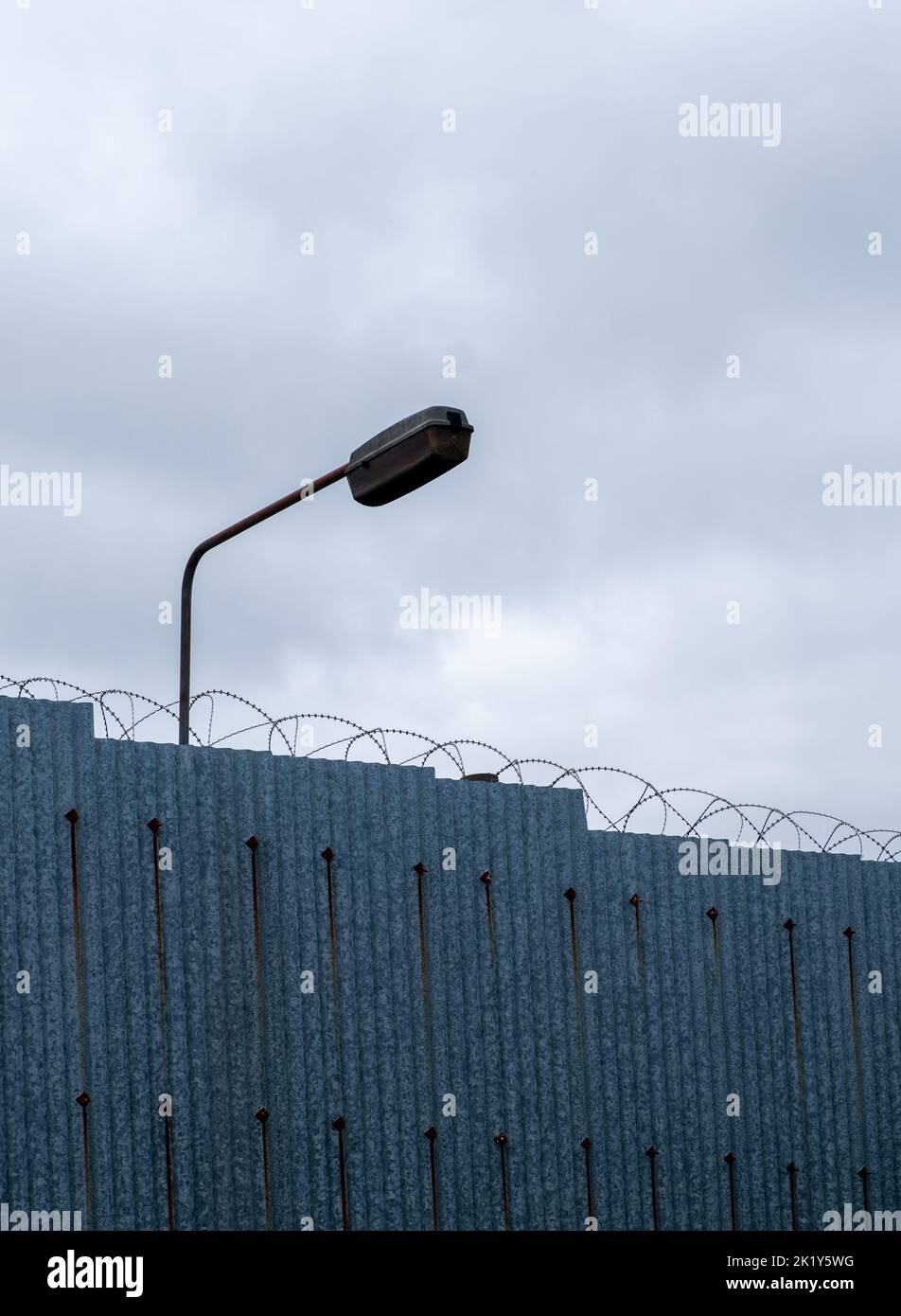 Prison high security fence topped with razer wire Stock Photo - Alamy