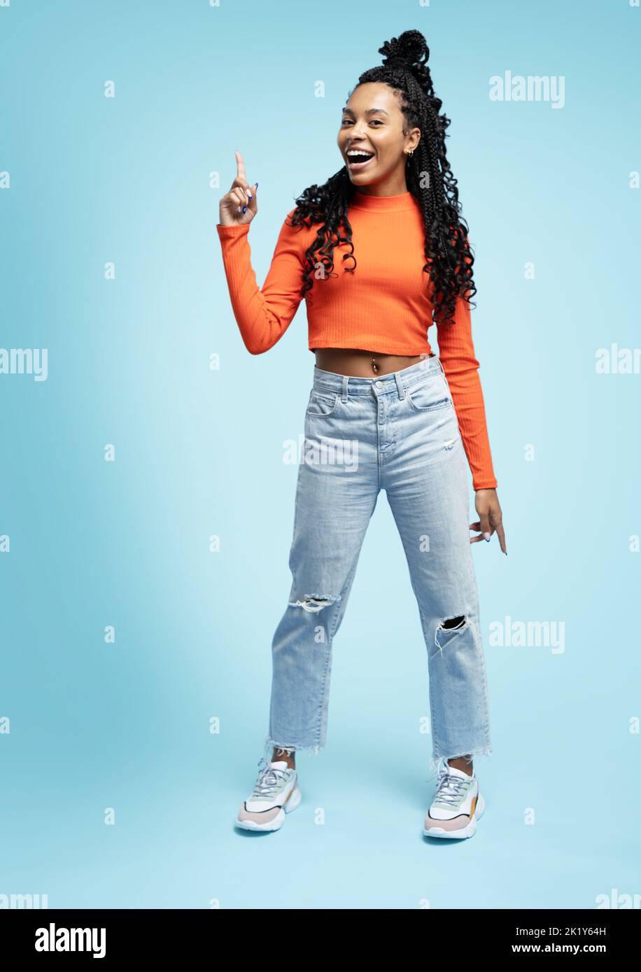 Cheerful Afro woman points away on copy space, discusses amazing promo ...