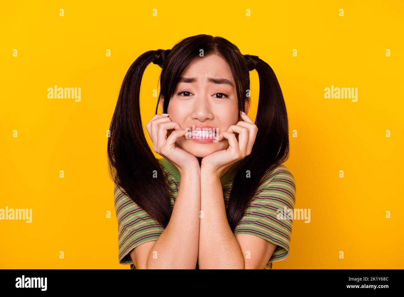 Portrait of young scared frightened loser girl bite her fingers have ...