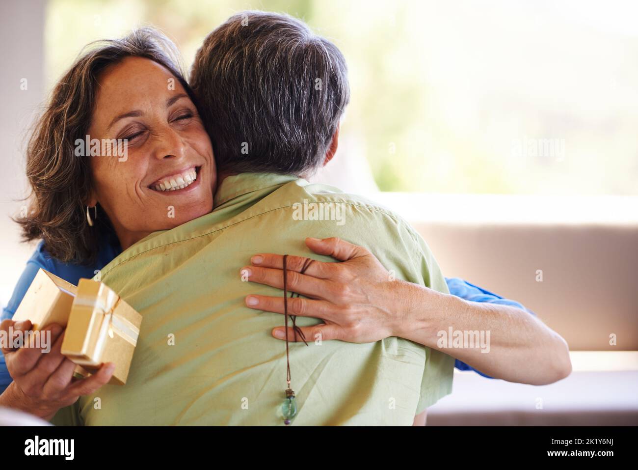 Very happy with the gift he got her. a woman hugging her husband Stock ...