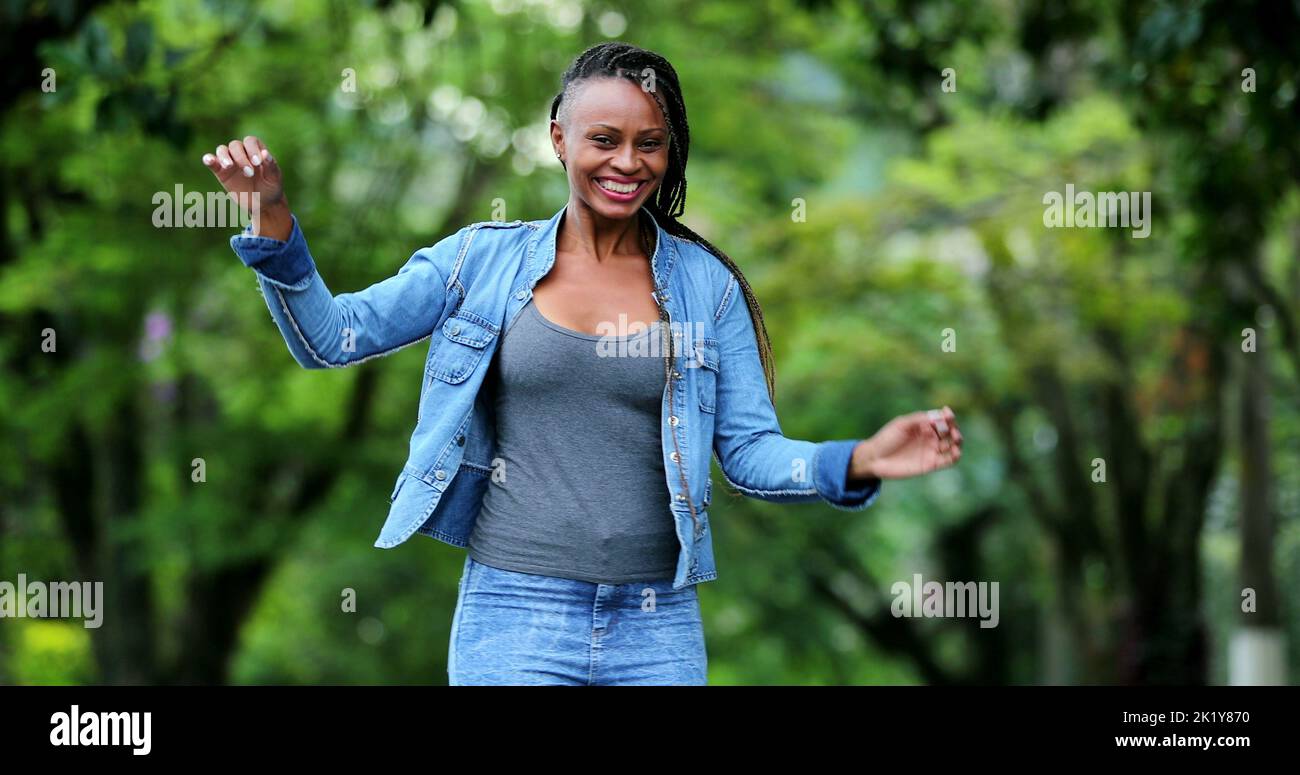Happy African woman dancing outside in street Stock Photo - Alamy