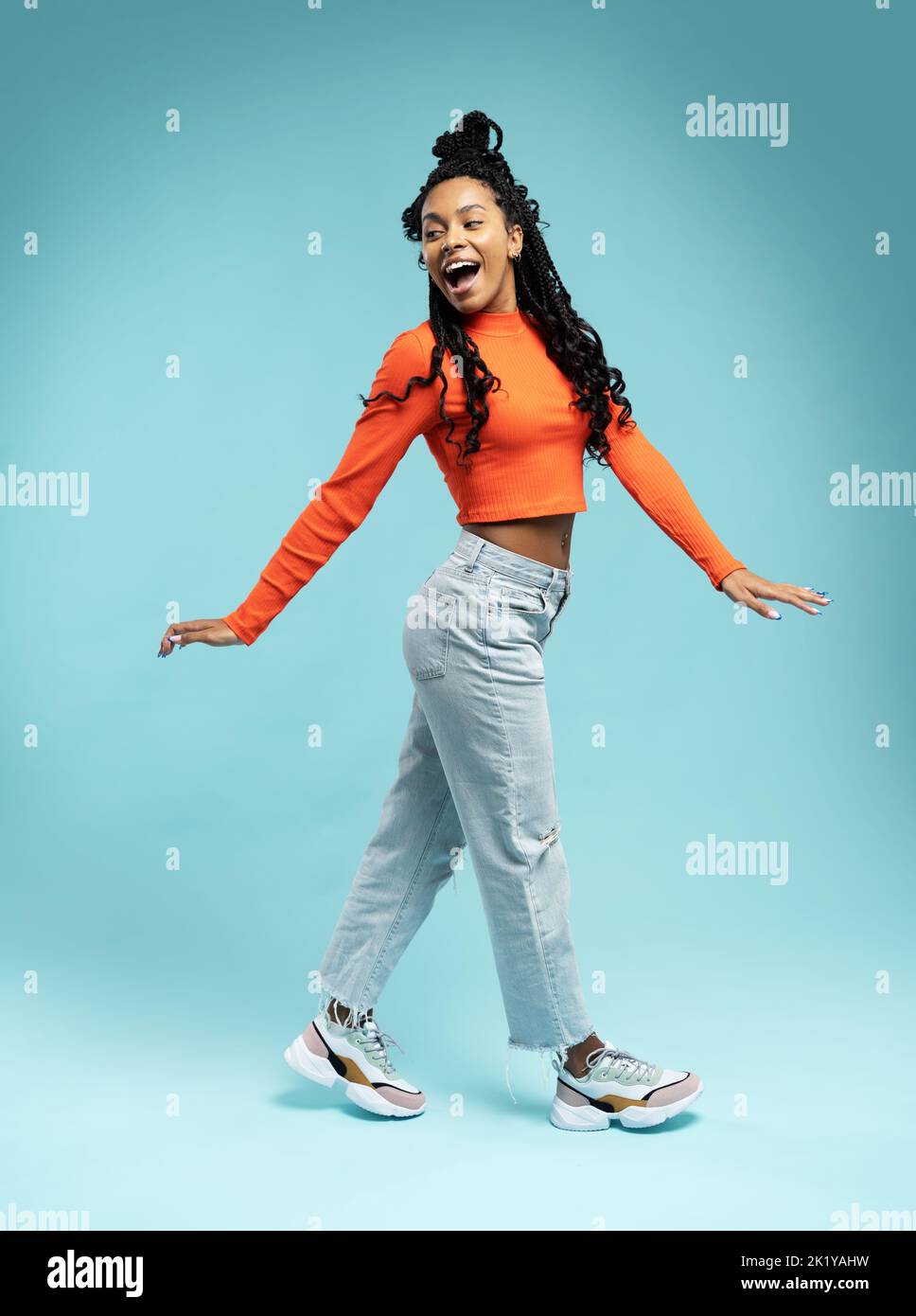 Young lovable woman with african hairstyle laughing during indoor ...