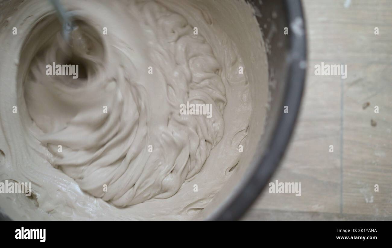 Mixing plaster solution in a bucket, using an electric drill. Mixing ...