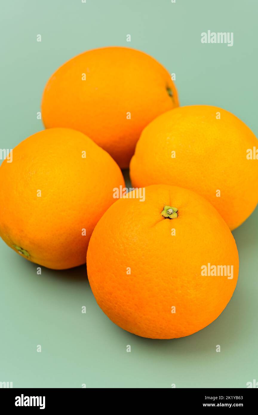 Four Whole Oranges on a Green background Stock Photo - Alamy