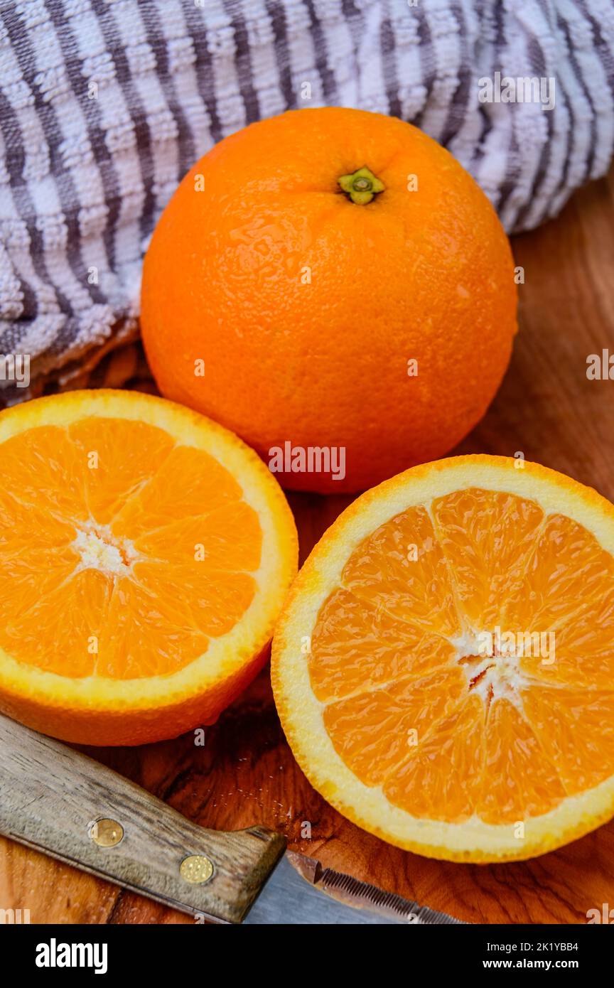 Whole and sliced Oranges on a cloth and wood background with cutting ...